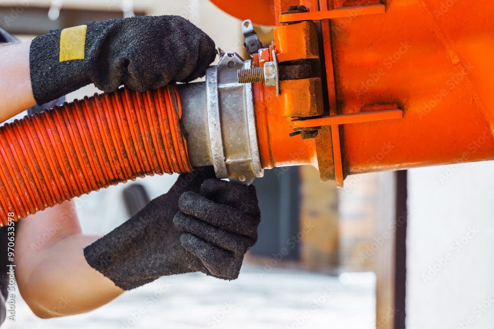 hand connects a suction hose to a sewage tanker truck. Sewer pumping ...