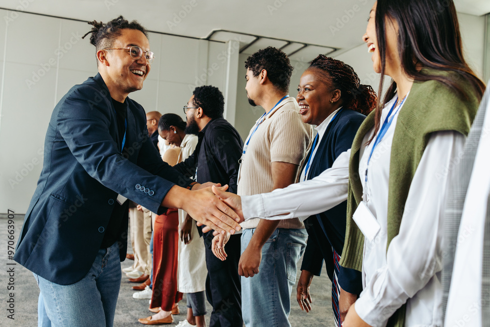 Business professionals shaking hands and networking in an office ...