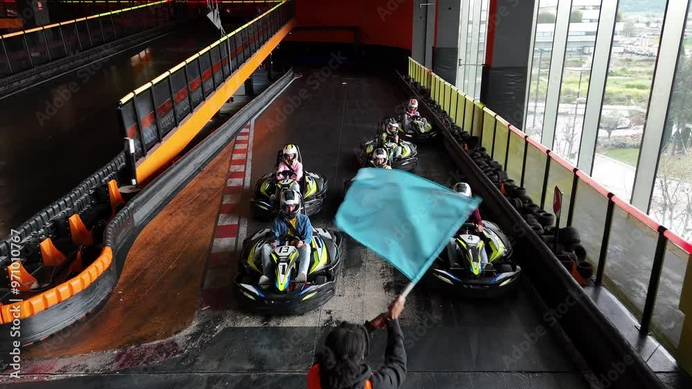 group of go-kart drivers crossing the finish line, with an official ...