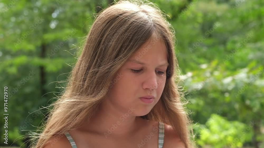 Sad preteen girl crying with tears on bench in the park close up ...