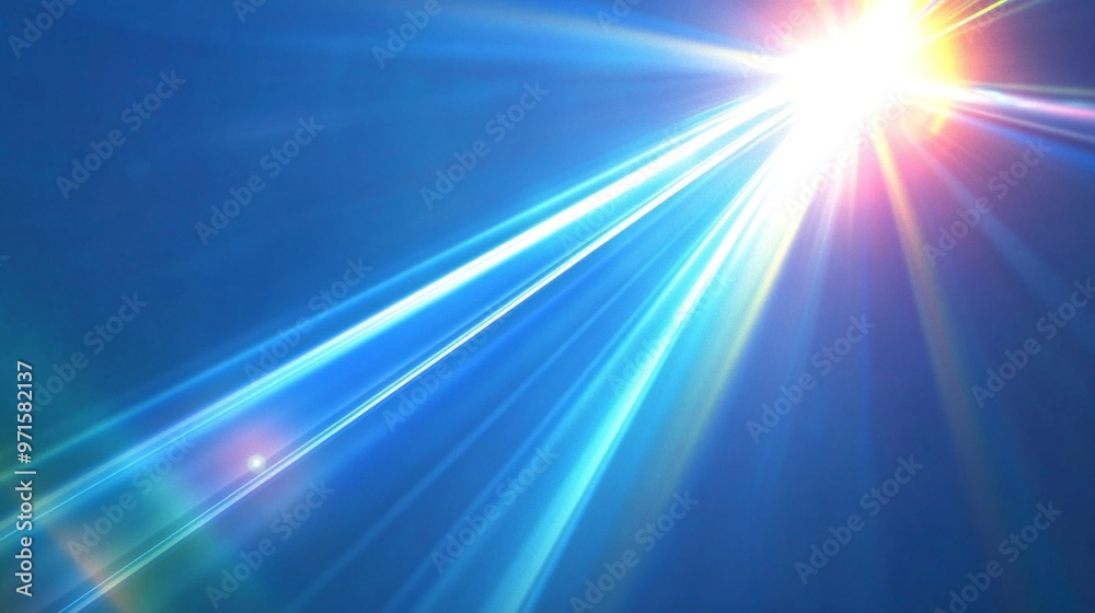 Intense beams of light shine against a deep blue sky. The rays create a ...