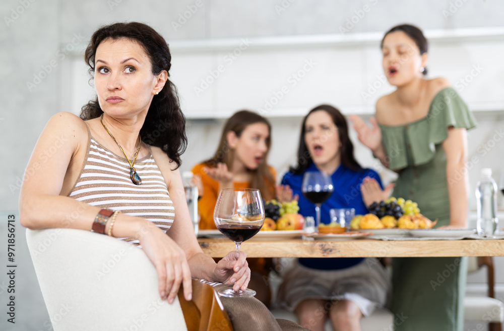 Caucasian girl is sitting in front of group of female friends, with her ...