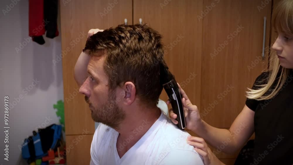 Daughter and son cutting their father's hair. Family time, hairstyle ...