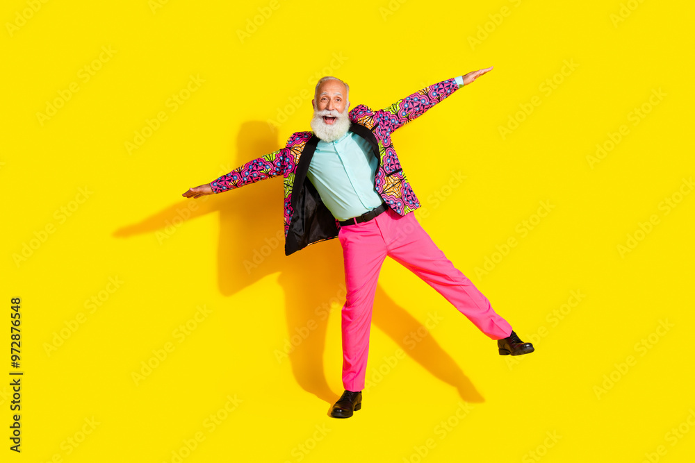 Full size photo of positive classy man stand one legs arms wings wear ...