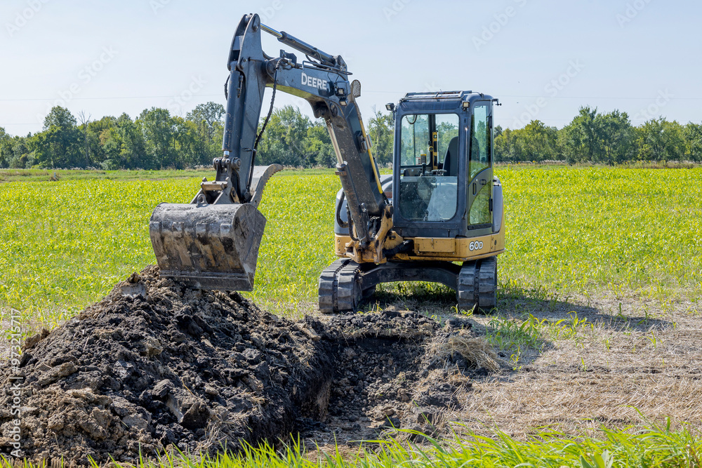 The front of a John Deere 60D backhoe exploring for a plugged tile line ...