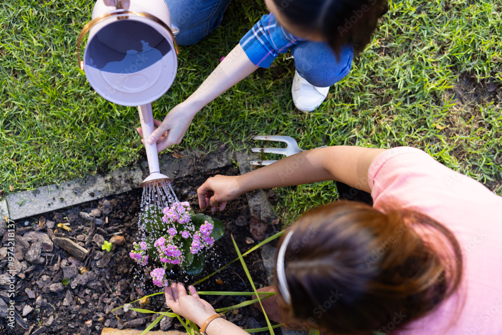 Watering flowers in garden, asian mother and daughter gardening ...
