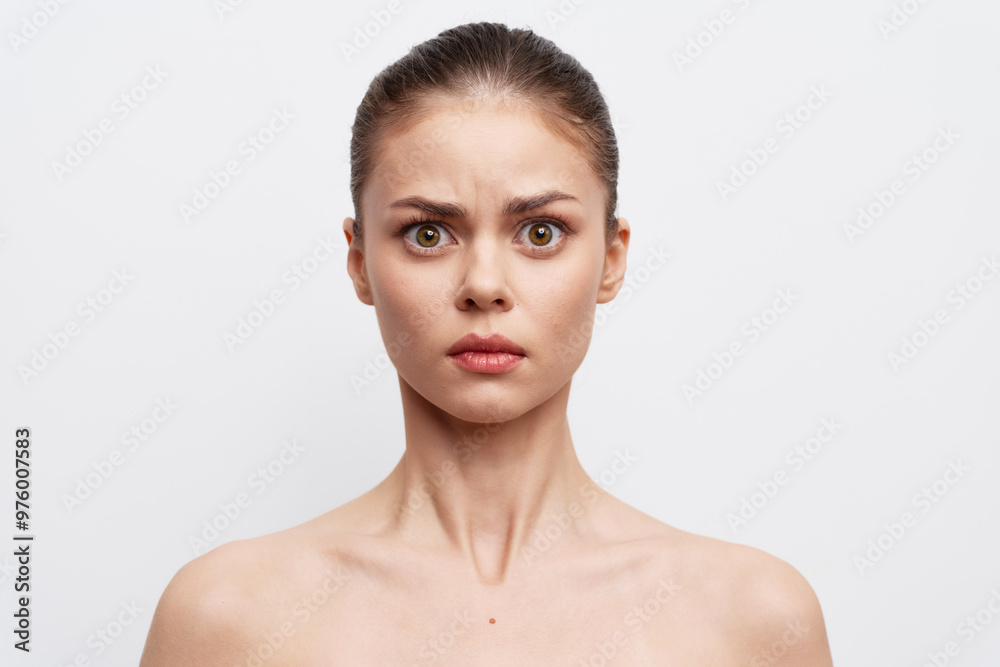 Woman with a surprised expression on a plain white background ...