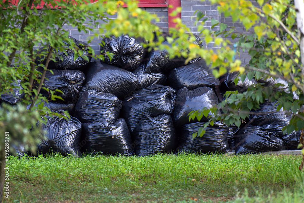 neat arrangement of black bags filled with garden waste, strategically ...