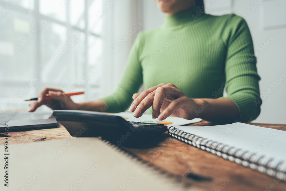 Financial Focus: A woman diligently manages her finances, calculating ...