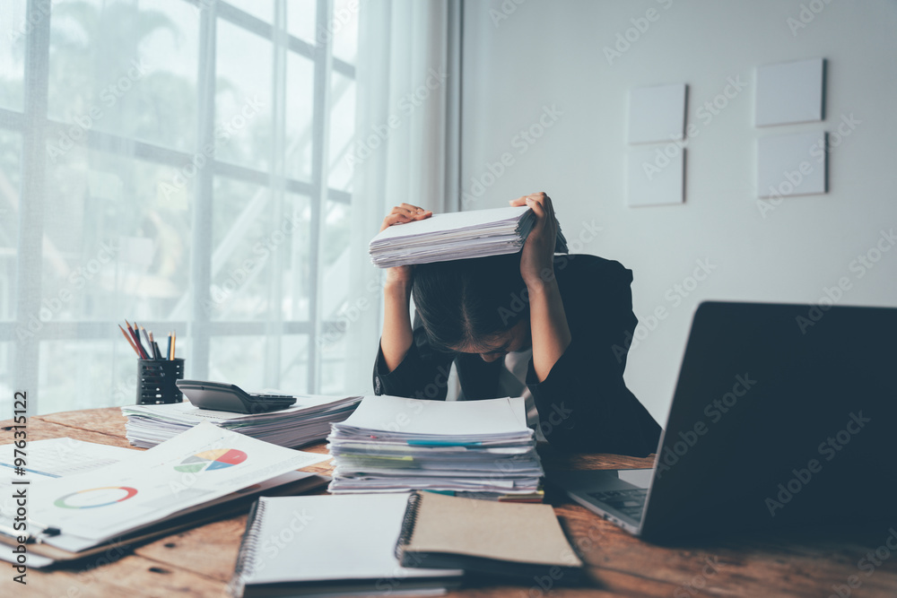 Overwhelmed and Exhausted: A young businesswoman sits at her desk ...
