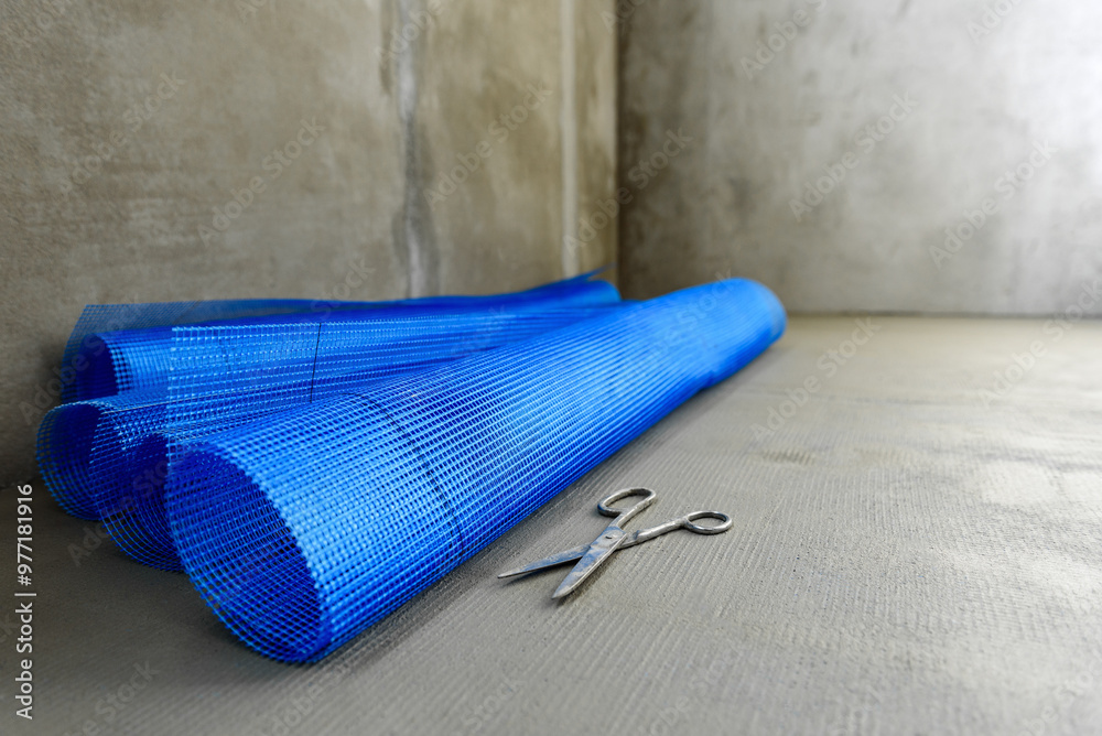 Blue fiberglass reinforcing mesh and scissors for applying construction ...
