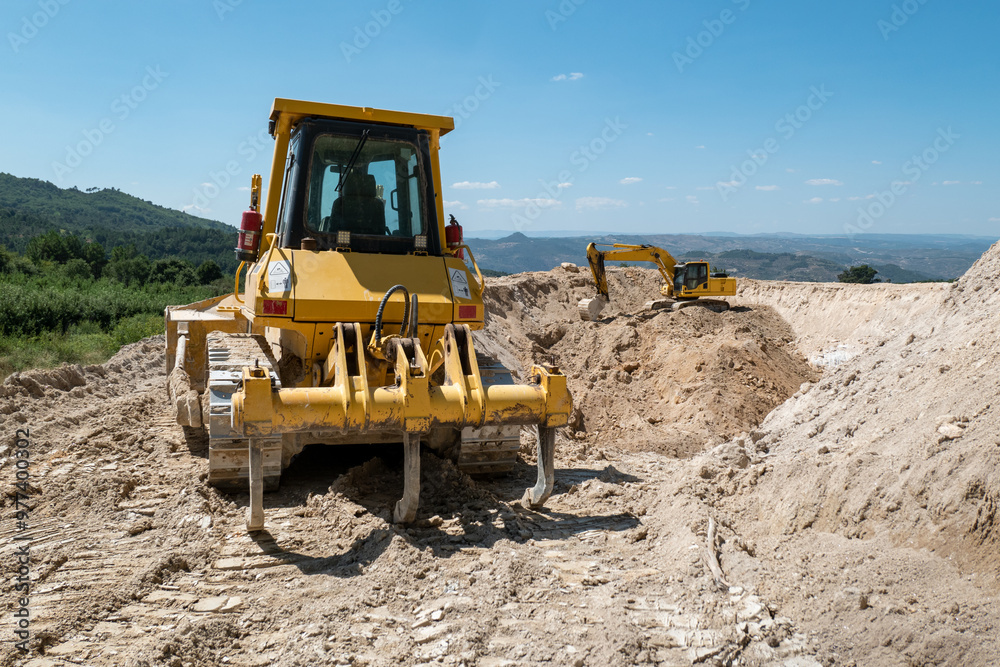 Buldózer e escavadora de esteiras na escavação de um charco ou ...