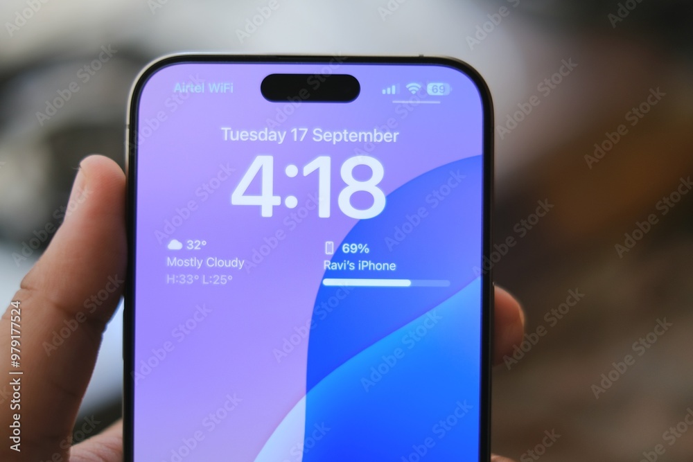 Man holding Apple iPhone 15 Pro Max with new apple update IOS 18 on the ...
