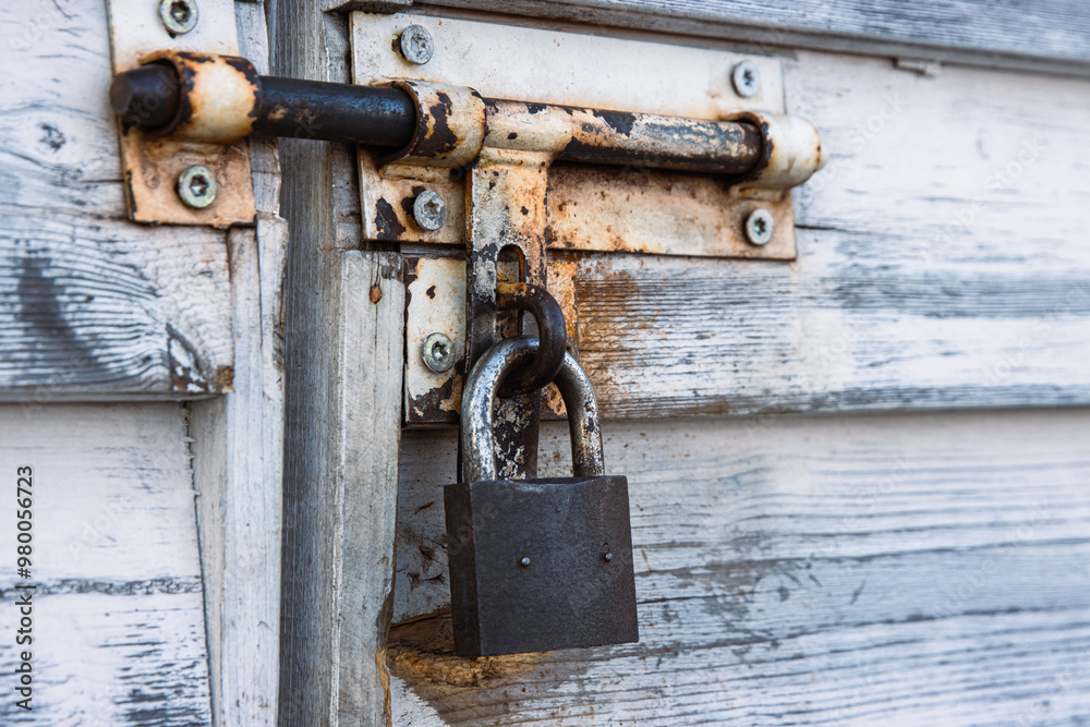 Rusty padlock and latch on white aged weathered closed wooden door ...