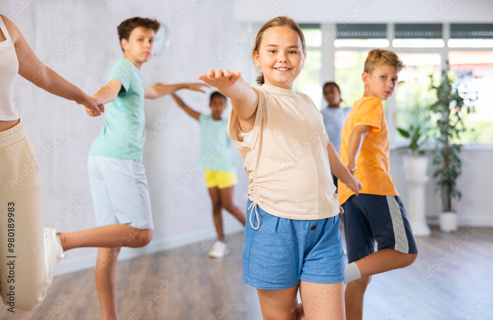 Smiling cute tween girl practicing vigorous dance in pair with boy ...