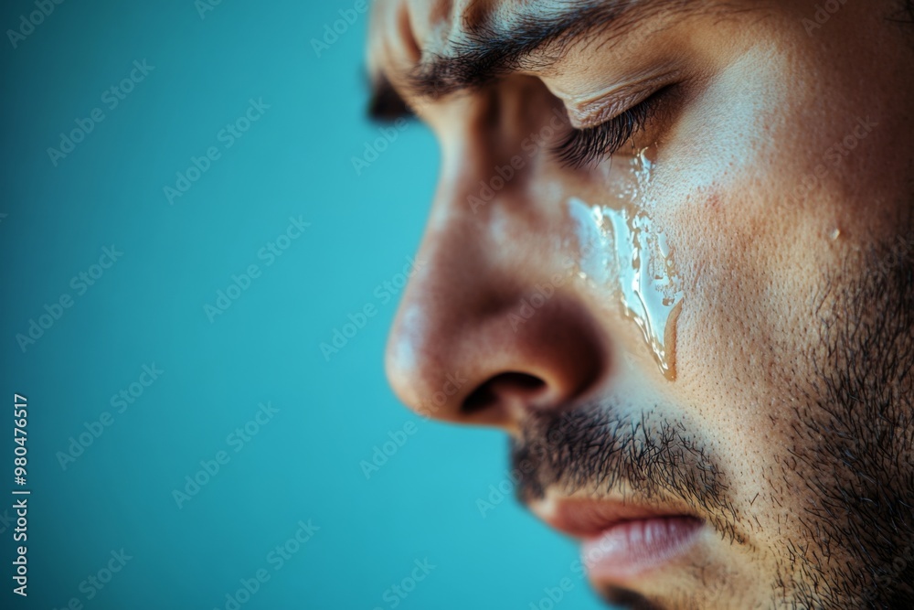Sad man crying with tears in eye on blue background. Teardrop on face ...