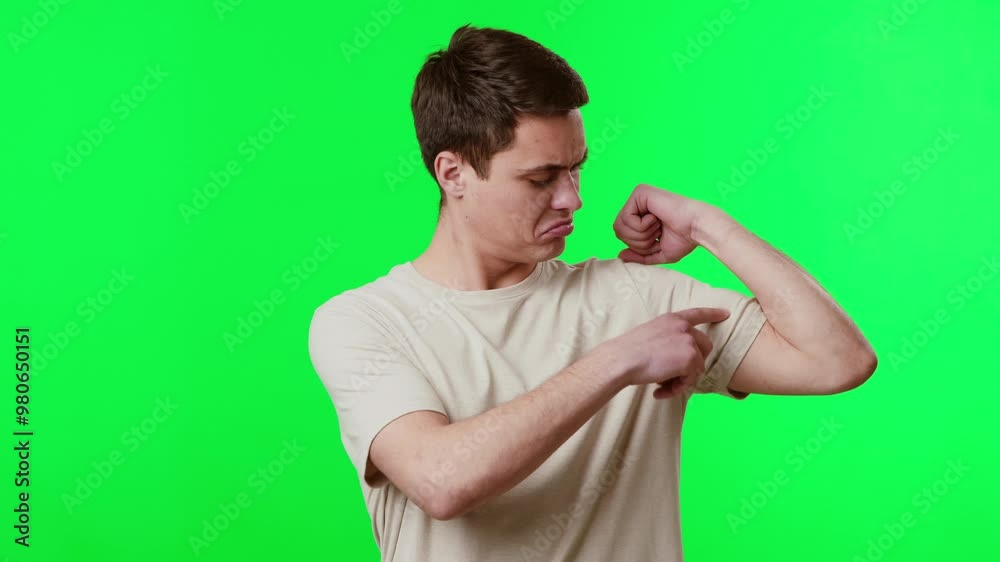 A young man is confidently flexing his arm muscles and pointing to his ...