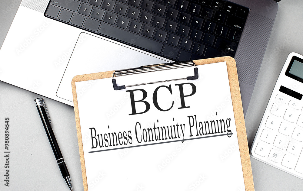 BCP business continuity planning text on a clipboard with a laptop, pen ...