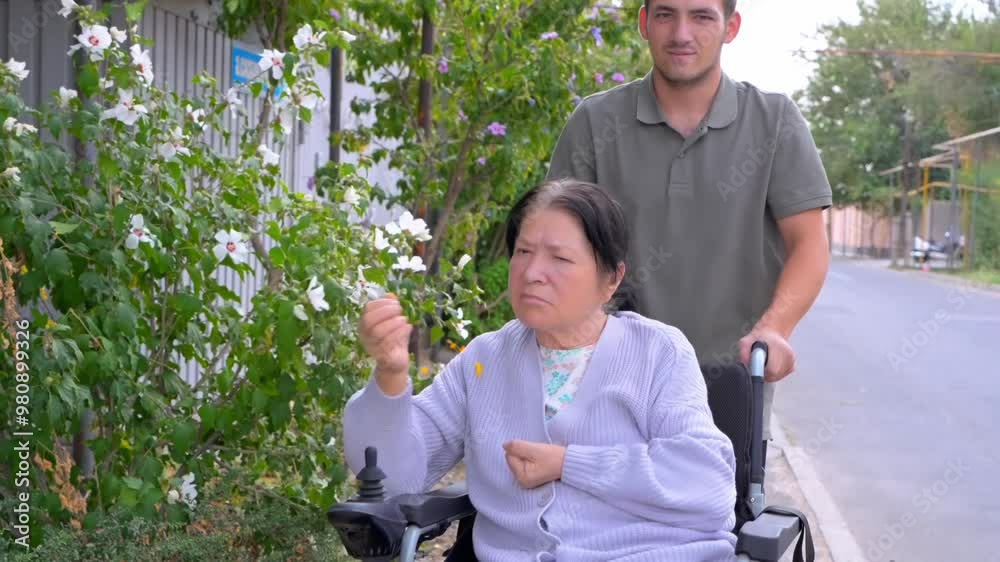 Sad senior woman sitting in wheelchair walking on road in city outdoor ...