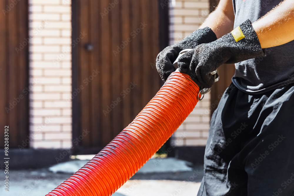 hand connects a suction hose to a sewage tanker truck. Sewer pumping ...