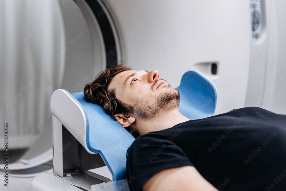 The patient lies inside an MRI or CT machine where the scan is performed. This high-tech ...