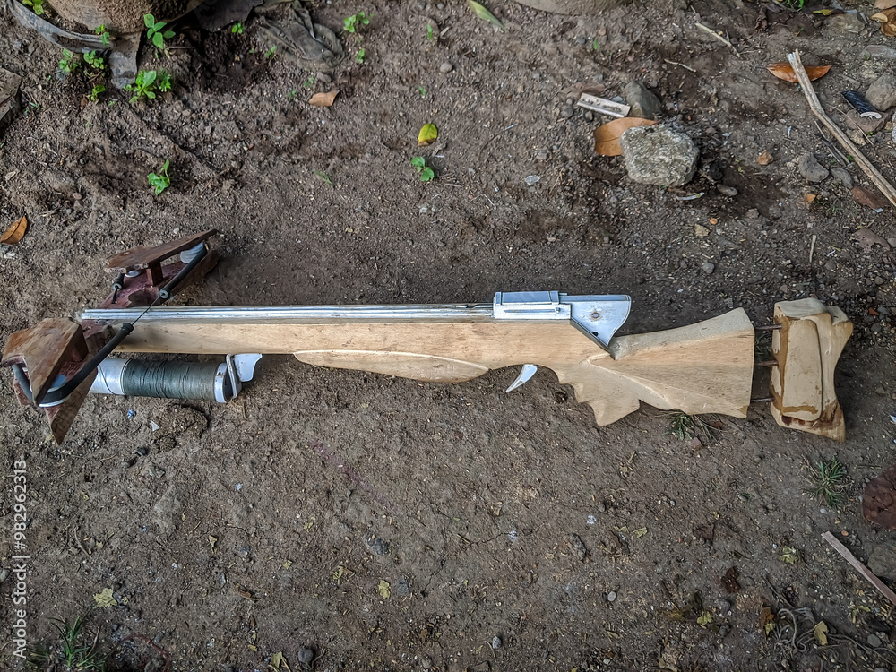 A handcrafted wooden crossbow with a visible string and trigger ...