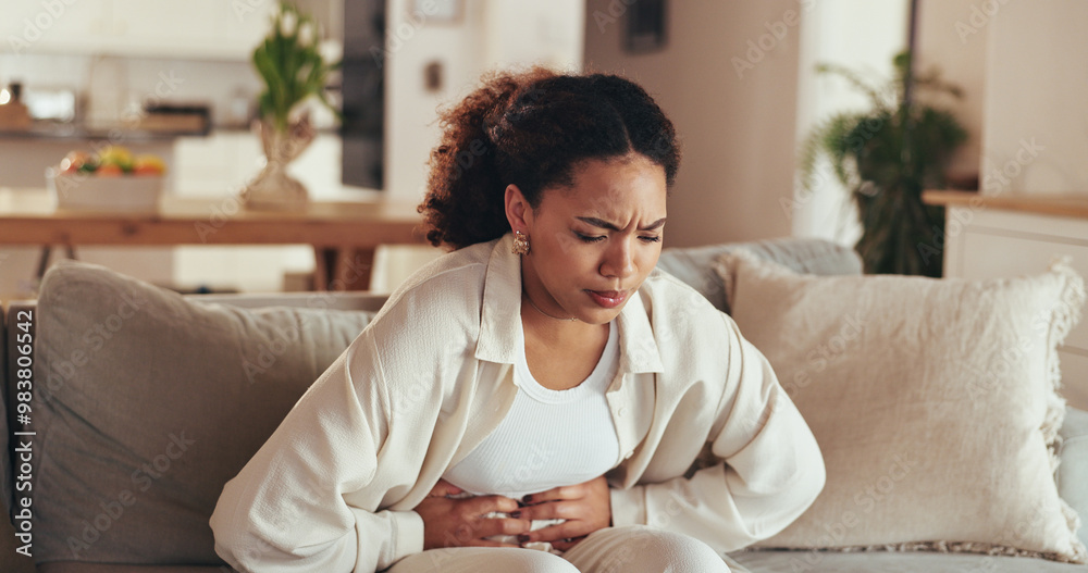 African, woman and stress with stomach pain at house for gut health ...