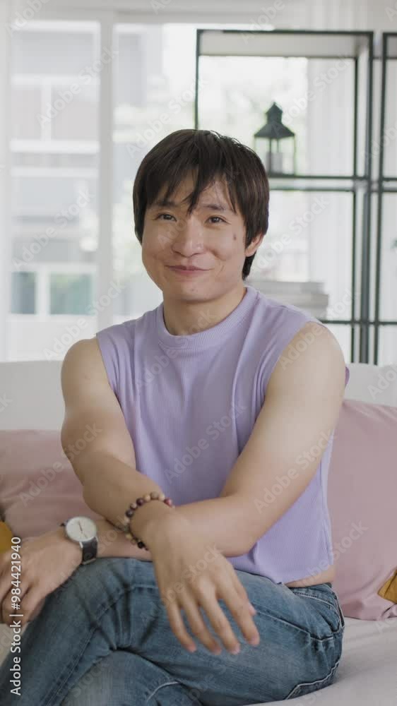 LGBT guy man Gen Z smile looking at camera sit easy relax on sofa couch ...