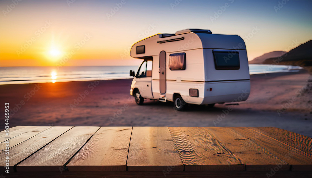 Wooden table in blurred motorhome camper tent at sunset on the beach ...