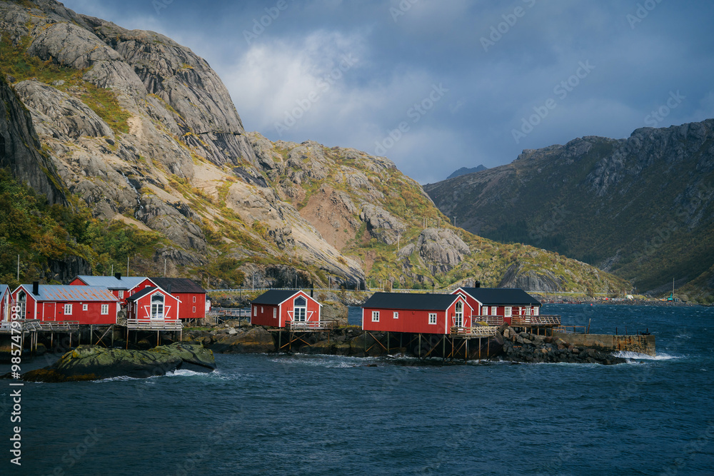 A charming red wooden cabin with a traditional grass roof. The cabin’s ...