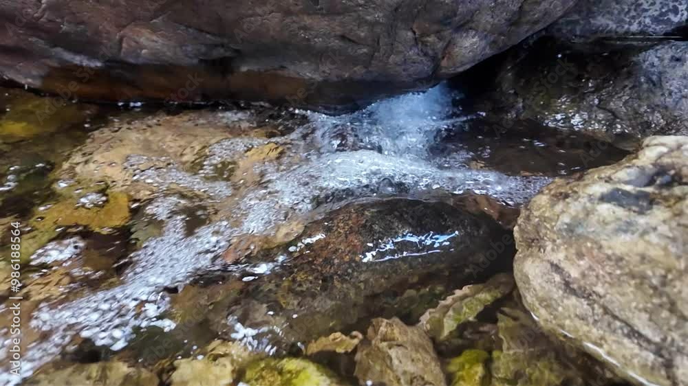 A video of water flowing down a rock, giving the illusion that it’s ...