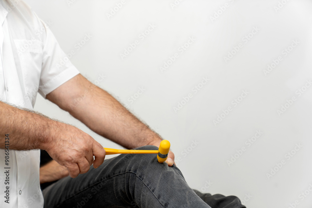 The neurologist testing knee reflex on a man patient using a hammer ...