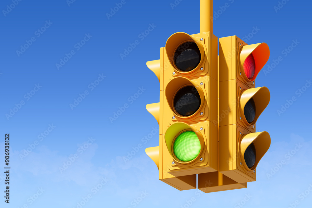 Yellow traffic light with a green signal illuminated, set against a ...