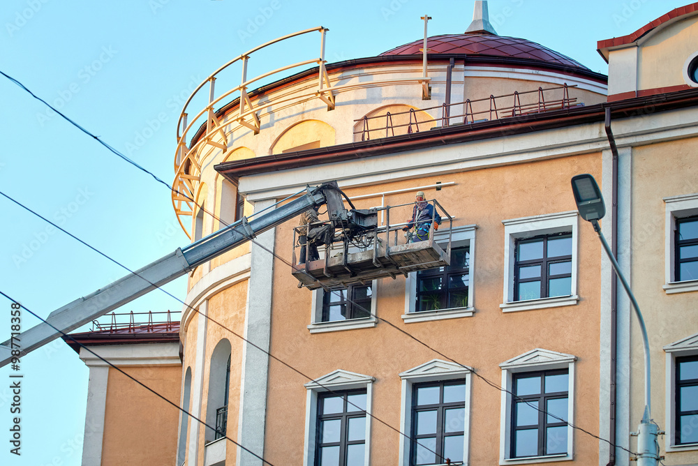 Workers using cradle crane to install an advertisement board on ...