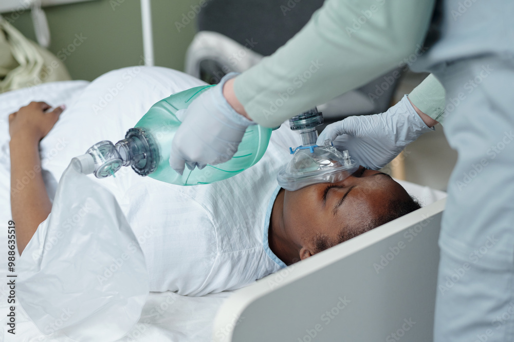 Medical professional giving emergency assistance with oxygen mask in ...