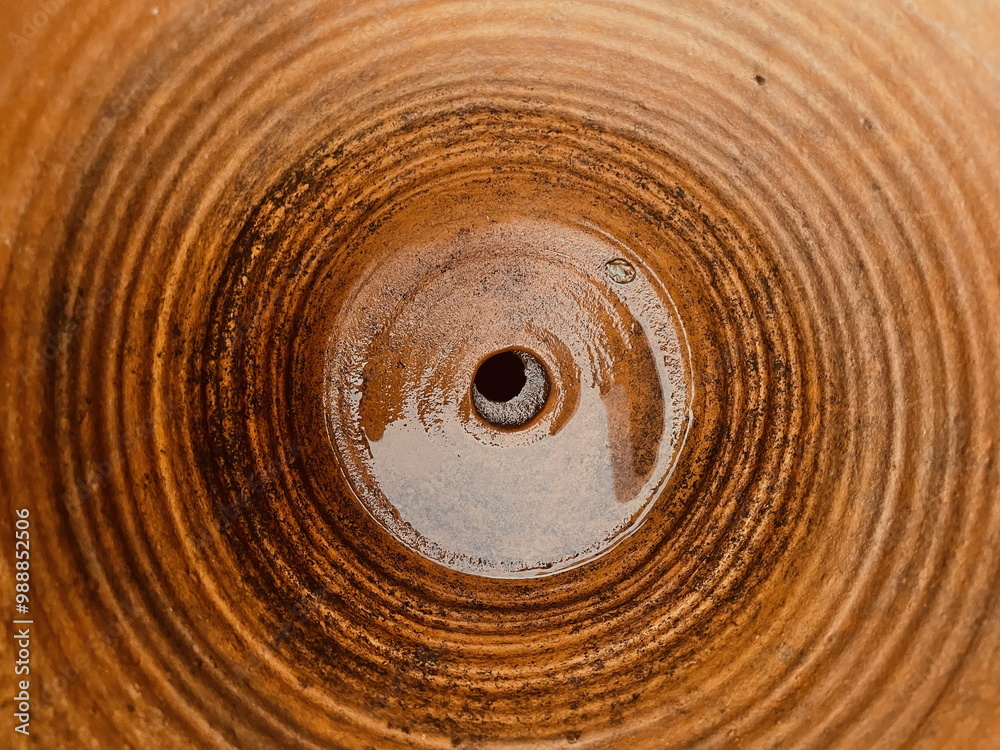 Rustic Spiral A close-up view of a terracotta pot's drainage hole, with ...