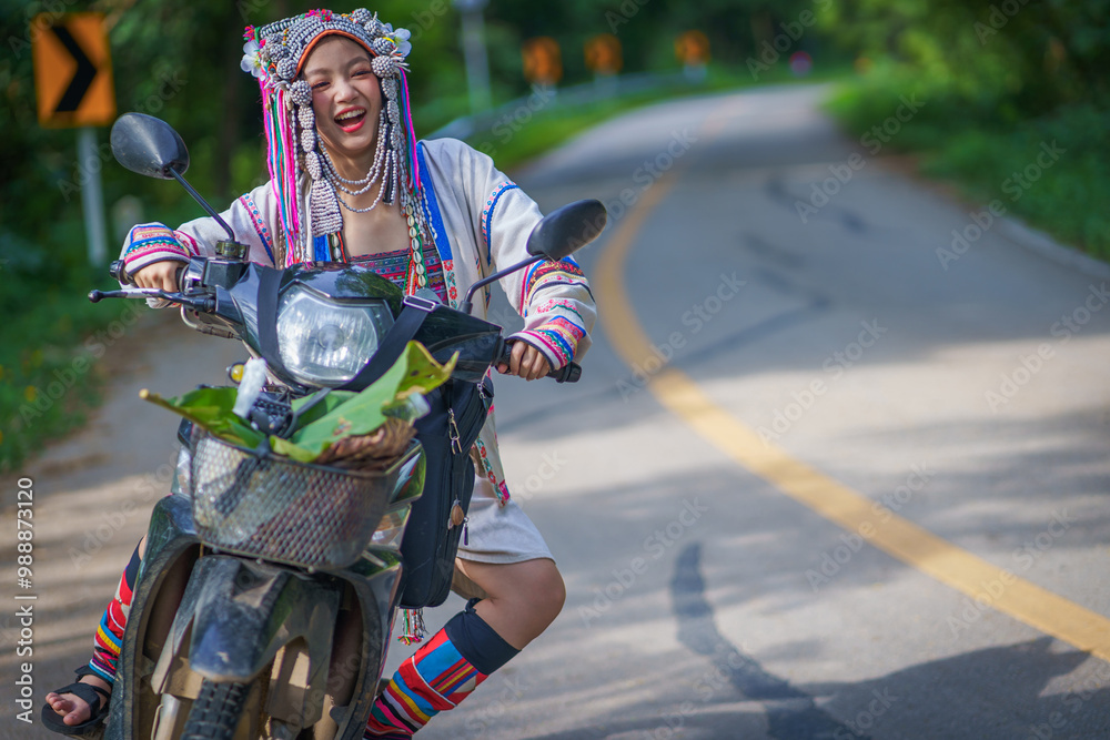 Beautiful Akha hill tribe girl wearing a traditional dress rides a ...