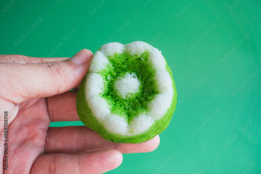 Hand holding Indonesian traditional cake it called Putu ayu cake or kue ...