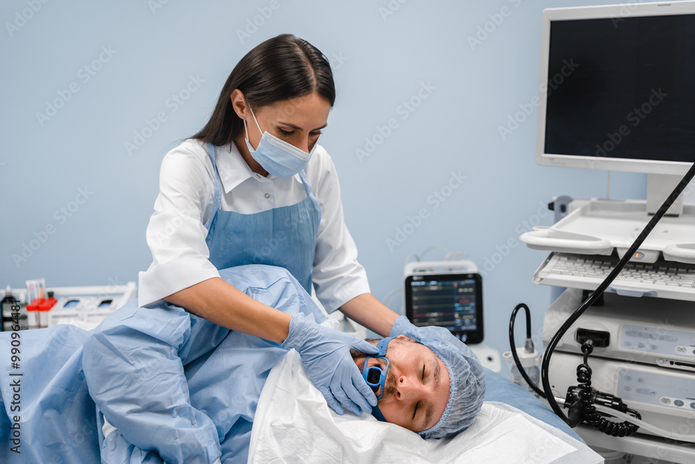 Man male patient laying at the bed while assistant holding special equipment at his mouth ...