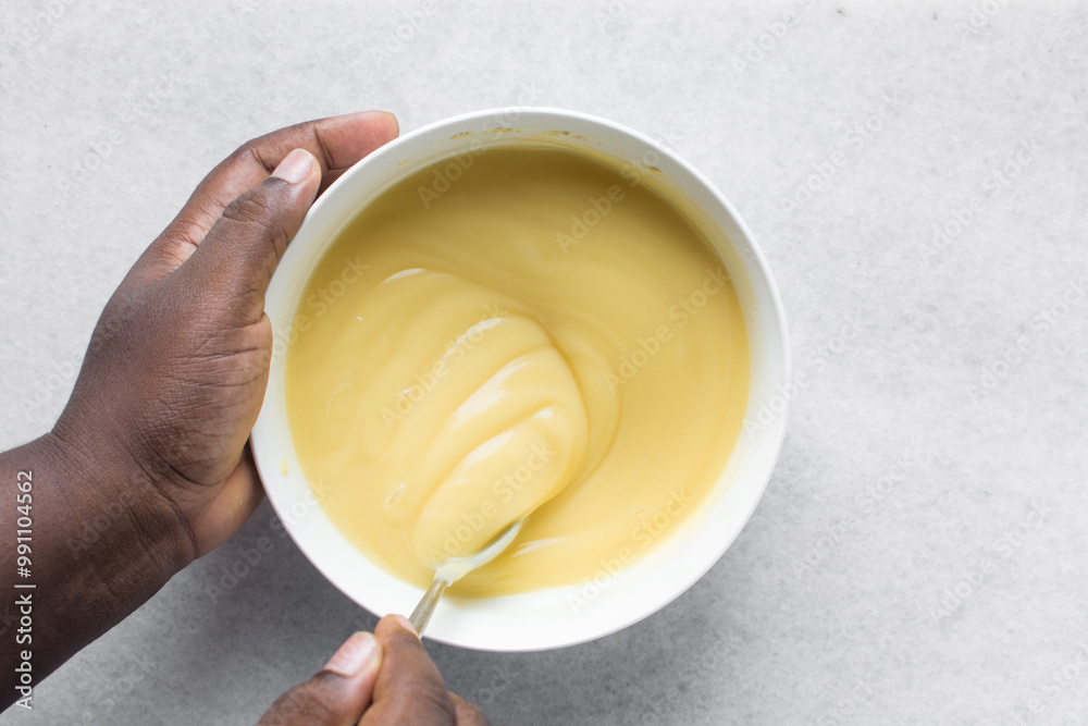 Overhead view of nigerian akamu being made in a white bowl, pap akamu ...