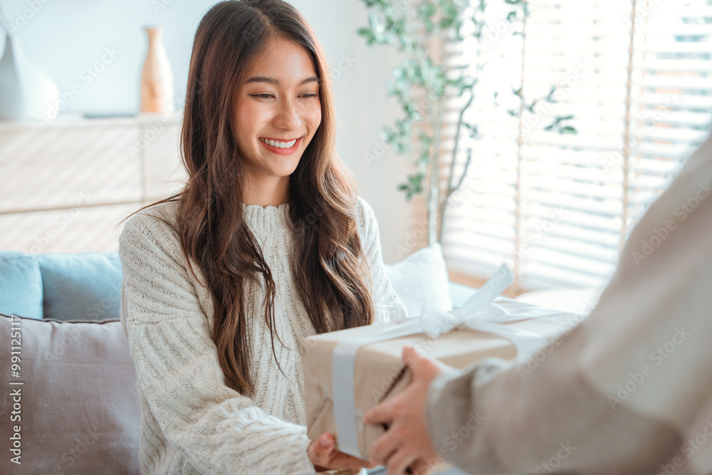 Excited asian woman getting surprise gift from her girlfriend at home ...
