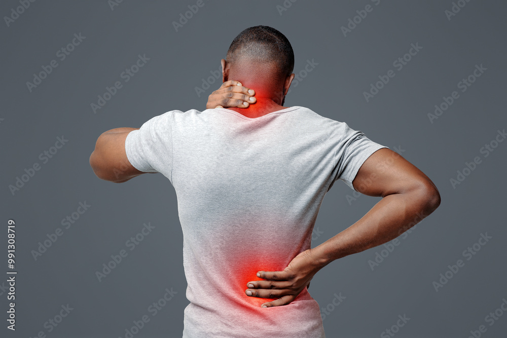 African man with neck and back pain, rubbing his painful body over ...