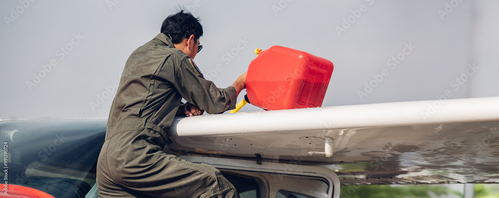 Pilot fueling low-wing propeller driven airplane. Refueling fuel in an ...