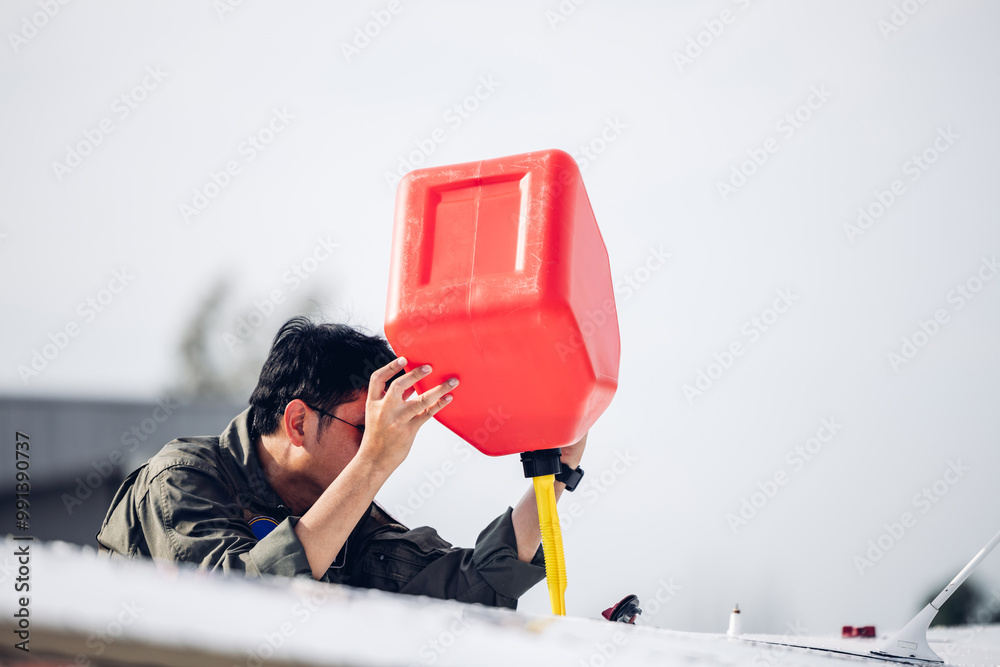 Pilot fueling low-wing propeller driven airplane. Refueling fuel in an ...
