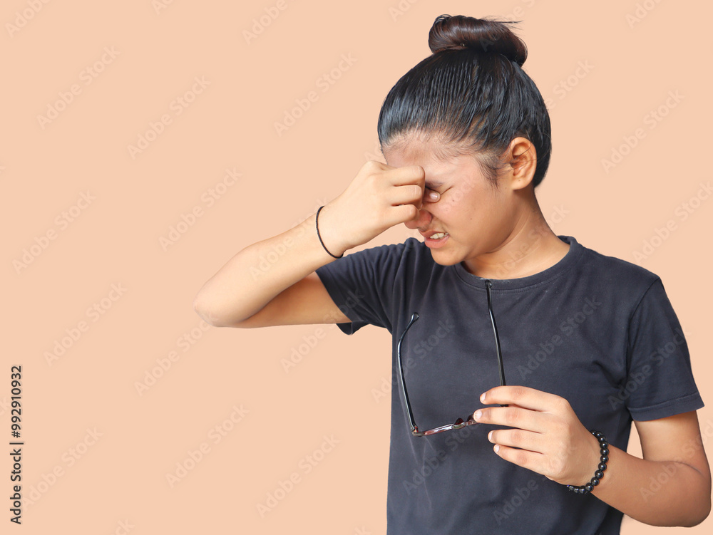 a young woman experiencing eye discomfort, pressing her eyes while ...