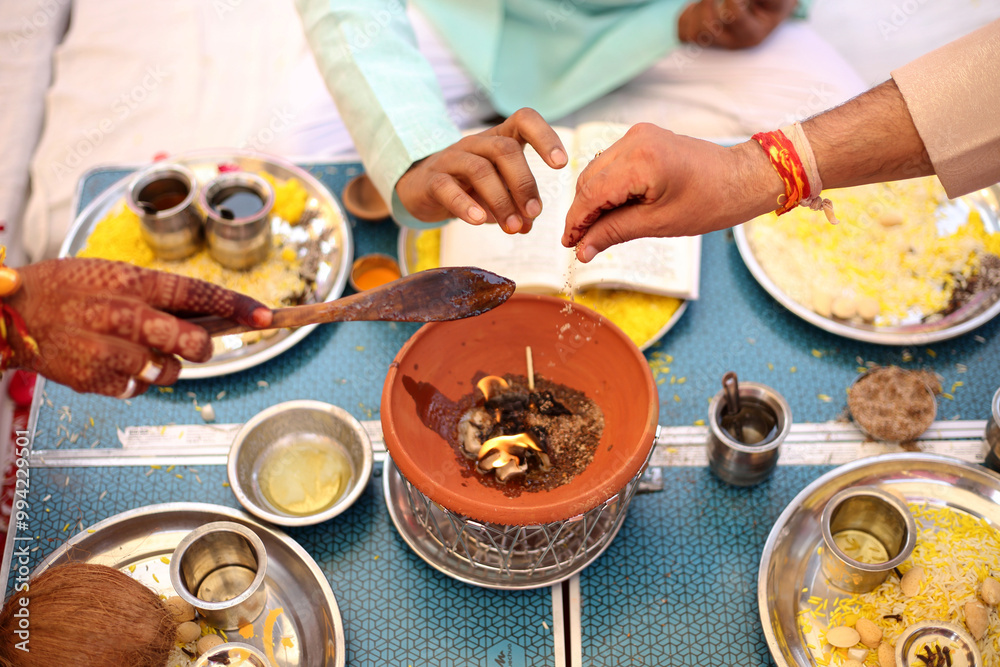 A Hindu ritual with offerings being made into a sacred fire, surrounded ...