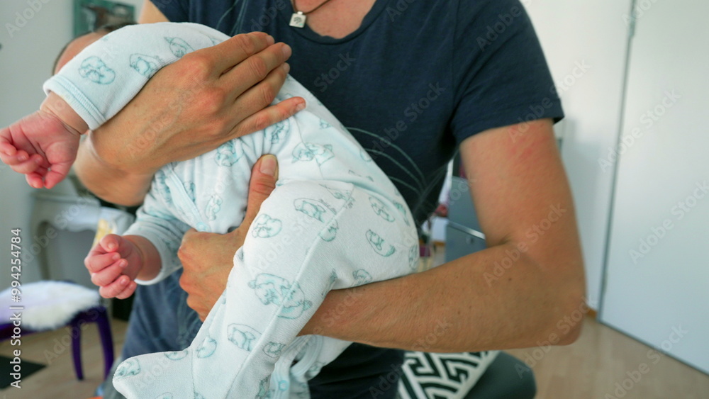 Orthopedist holding newborn in a secure position to relieve body pains ...