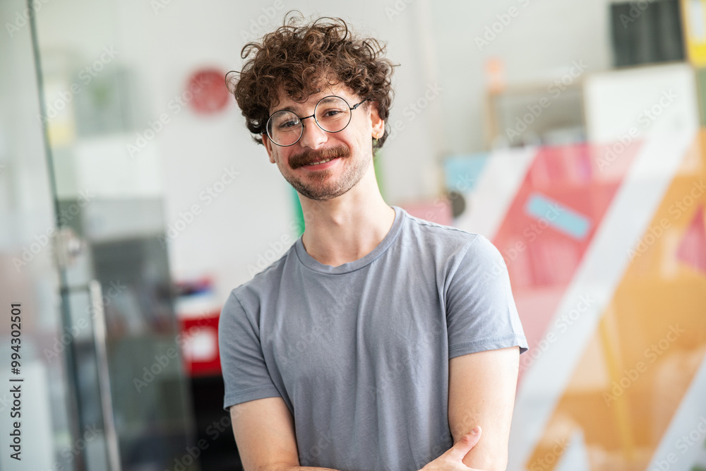 In his college office, a determined male student stands confidently, a ...