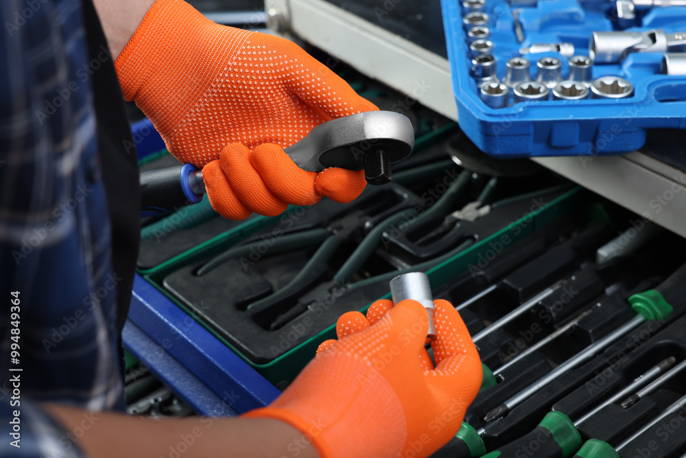 Auto mechanic with torque wrench and different tools at automobile ...