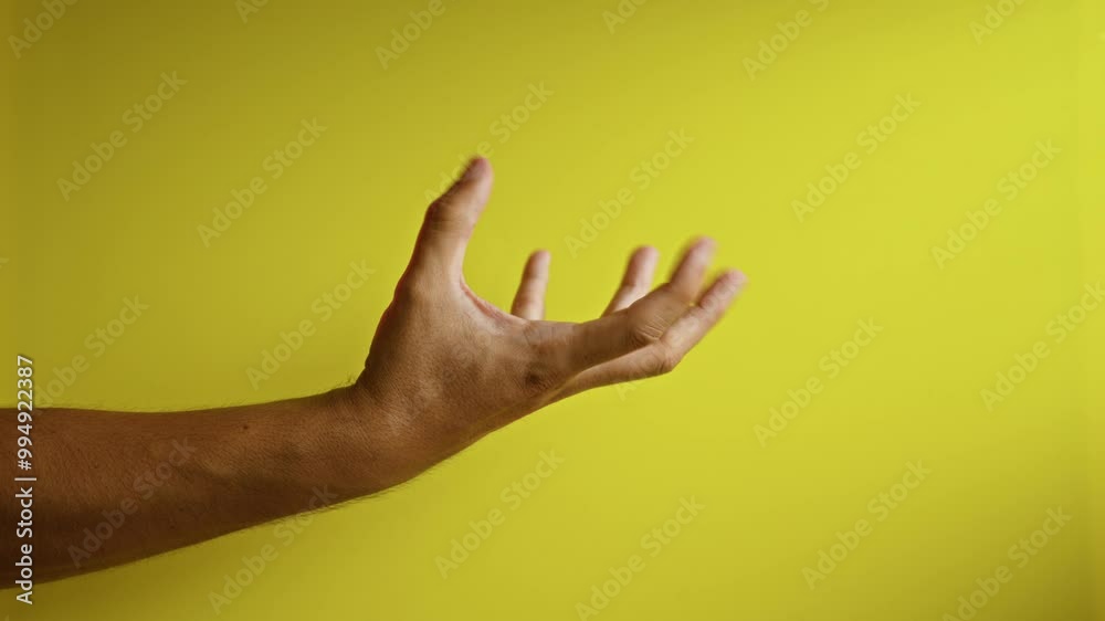 Male hand gestures against a vibrant yellow background create visual ...